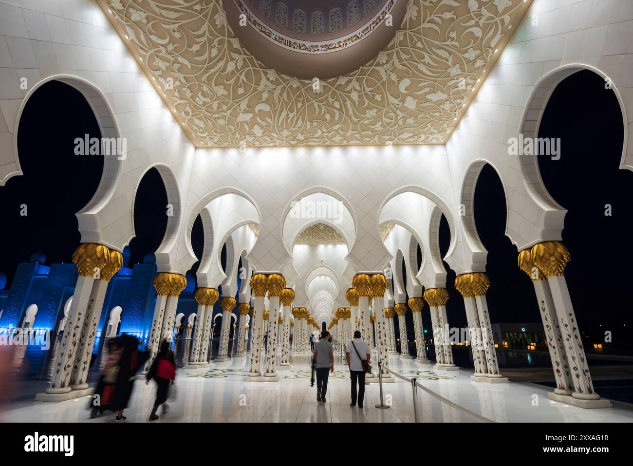 Night view of people walking through the illuminated corridor of Sheikh ...