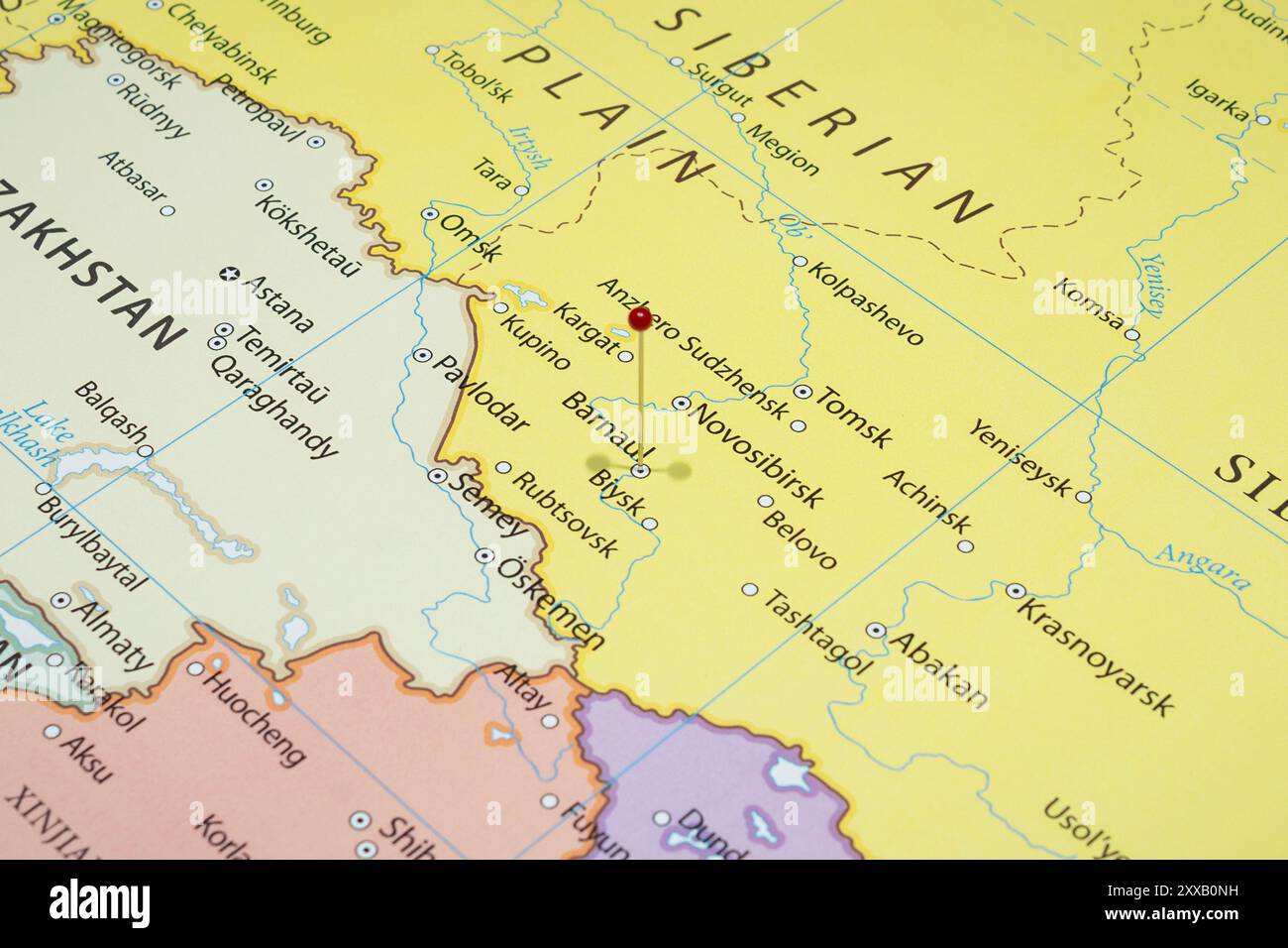 Close up to a Barnaul city with a red pin needle into Russia country ...