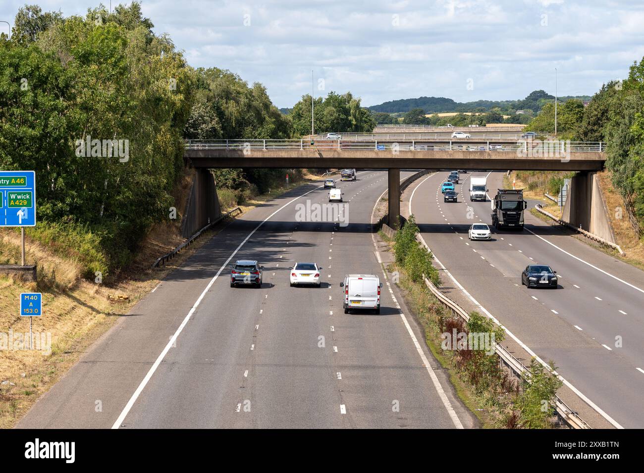 Traffic moving on multi-lane highway under bridge on sunny summer day ...