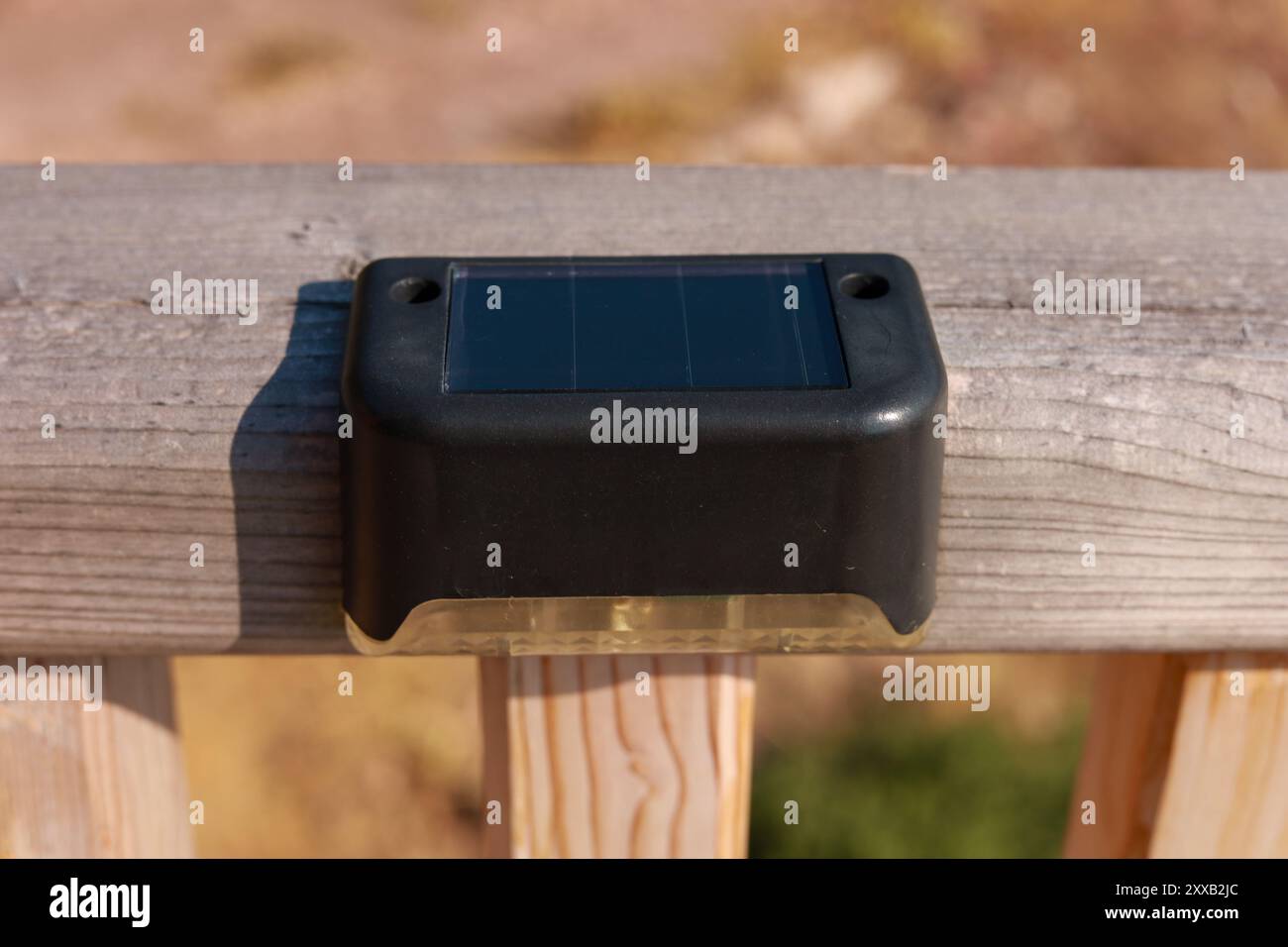 Small solar powered led light with motion sensor on wooden terrace ...