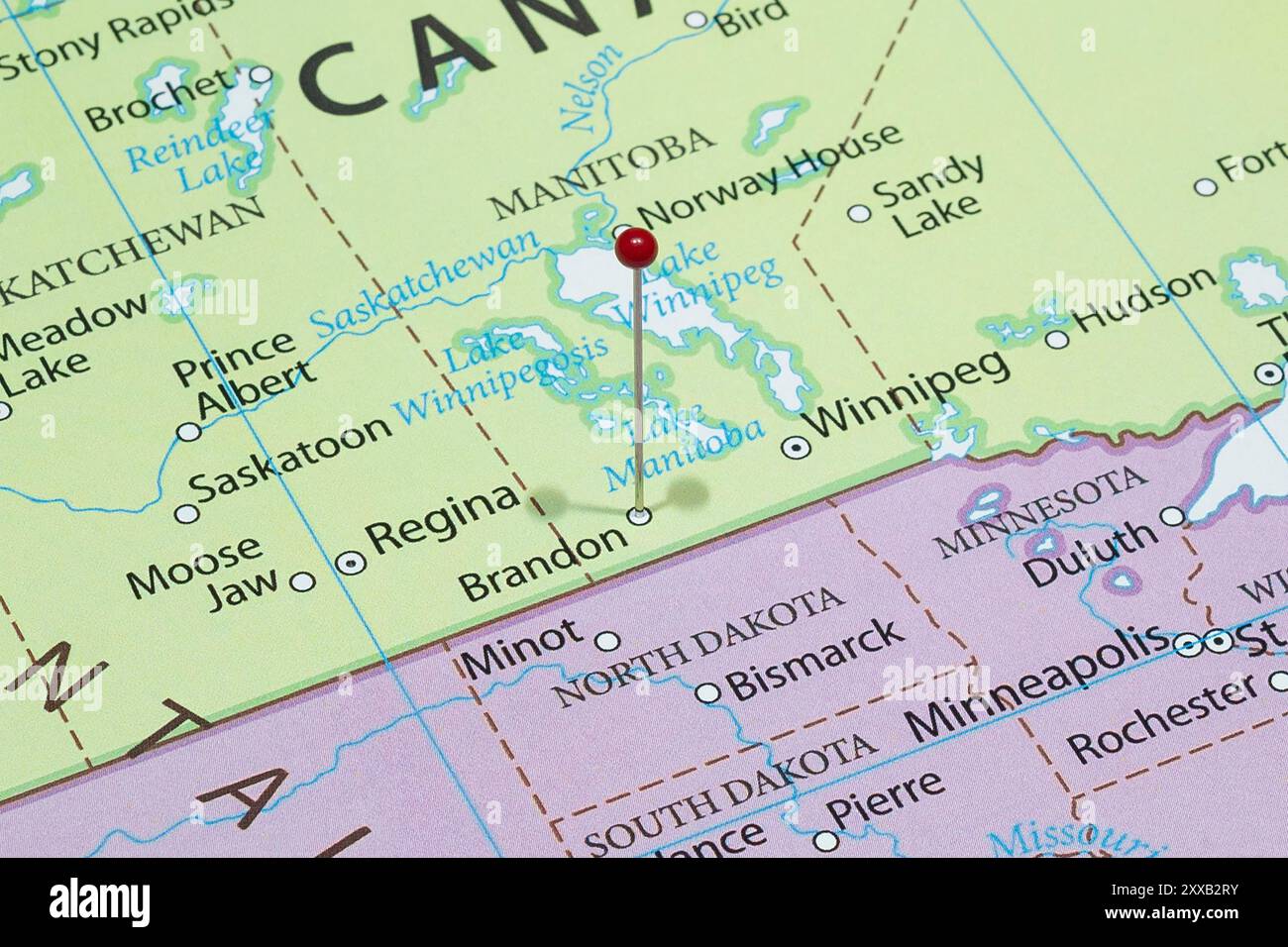 Close up to a Brandon city with a red pin needle into Canada country ...