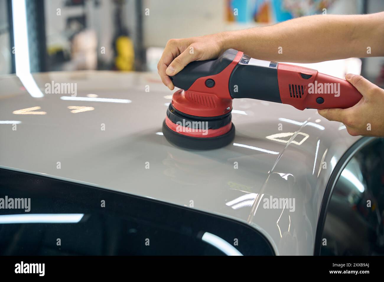 Master uses a modern polishing machine in process of detailing Stock ...