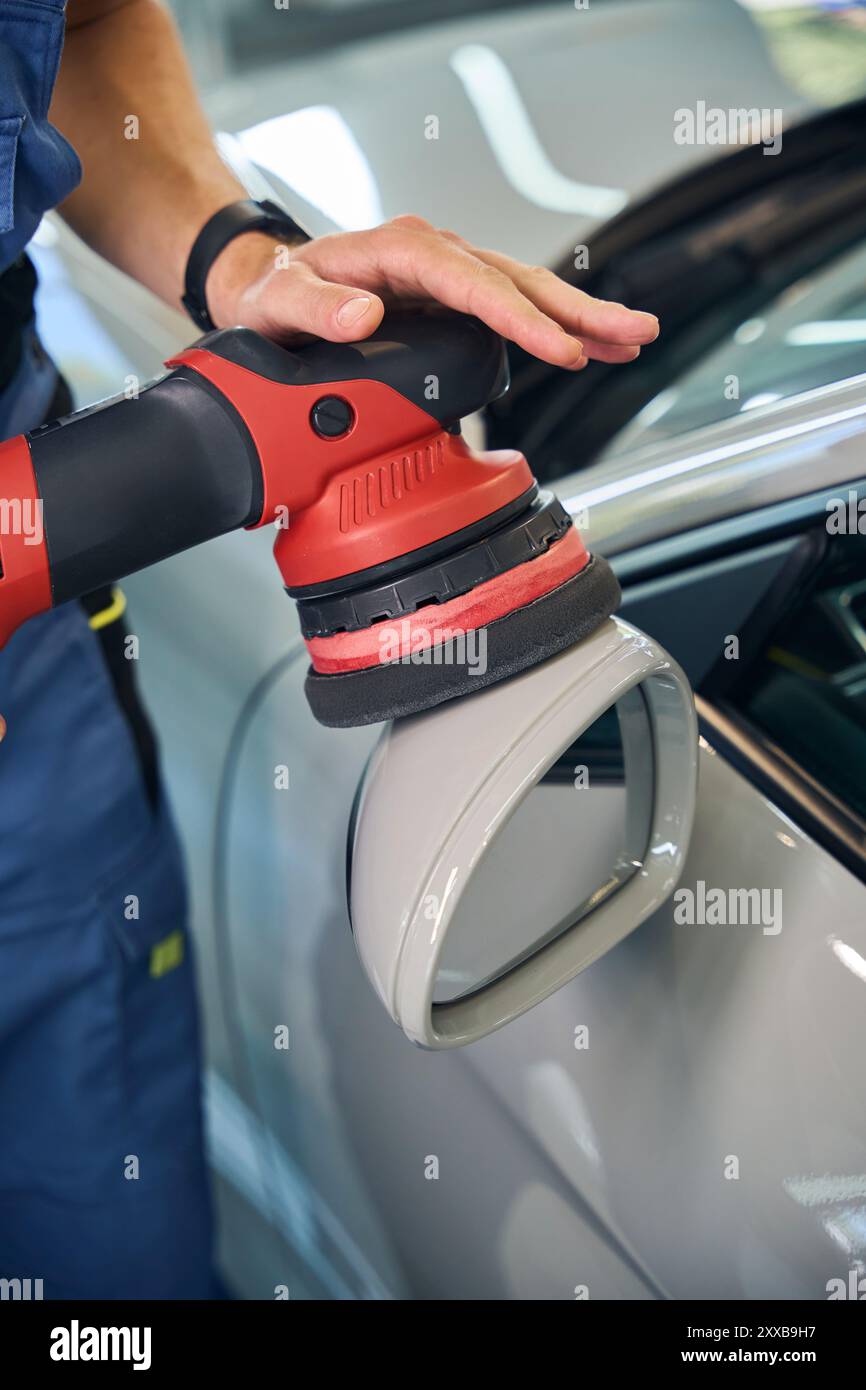 Worker polishes the side mirror of a car Stock Photo - Alamy