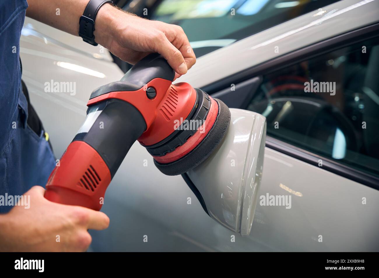 Auto repair shop employee polishes the side mirror of car Stock Photo ...