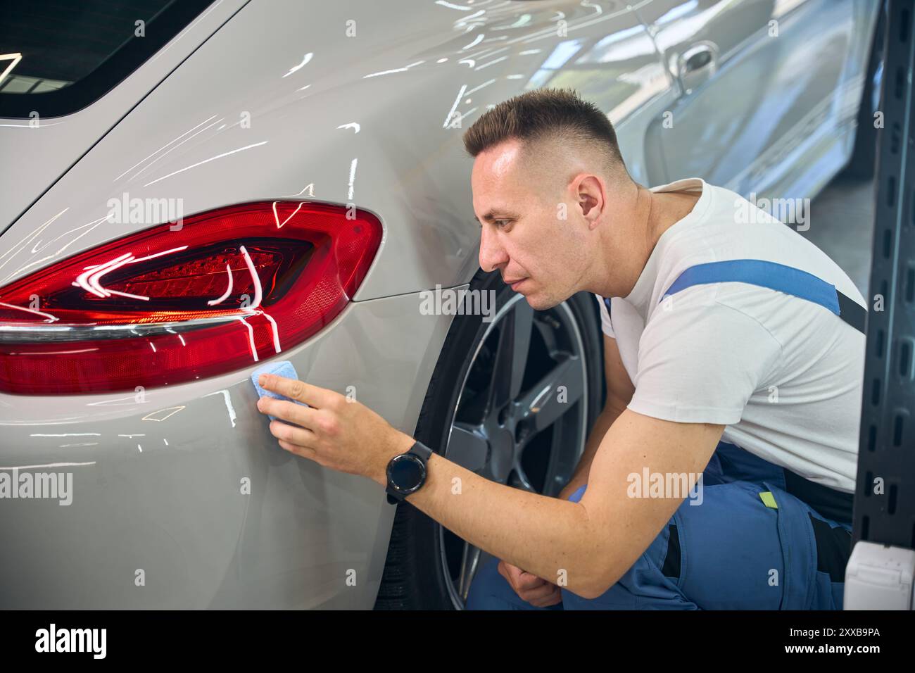 Male gently cleans the car body during car detailing Stock Photo - Alamy