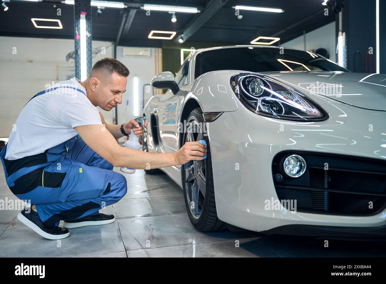 Car service employee uses special materials in process of car detailing ...