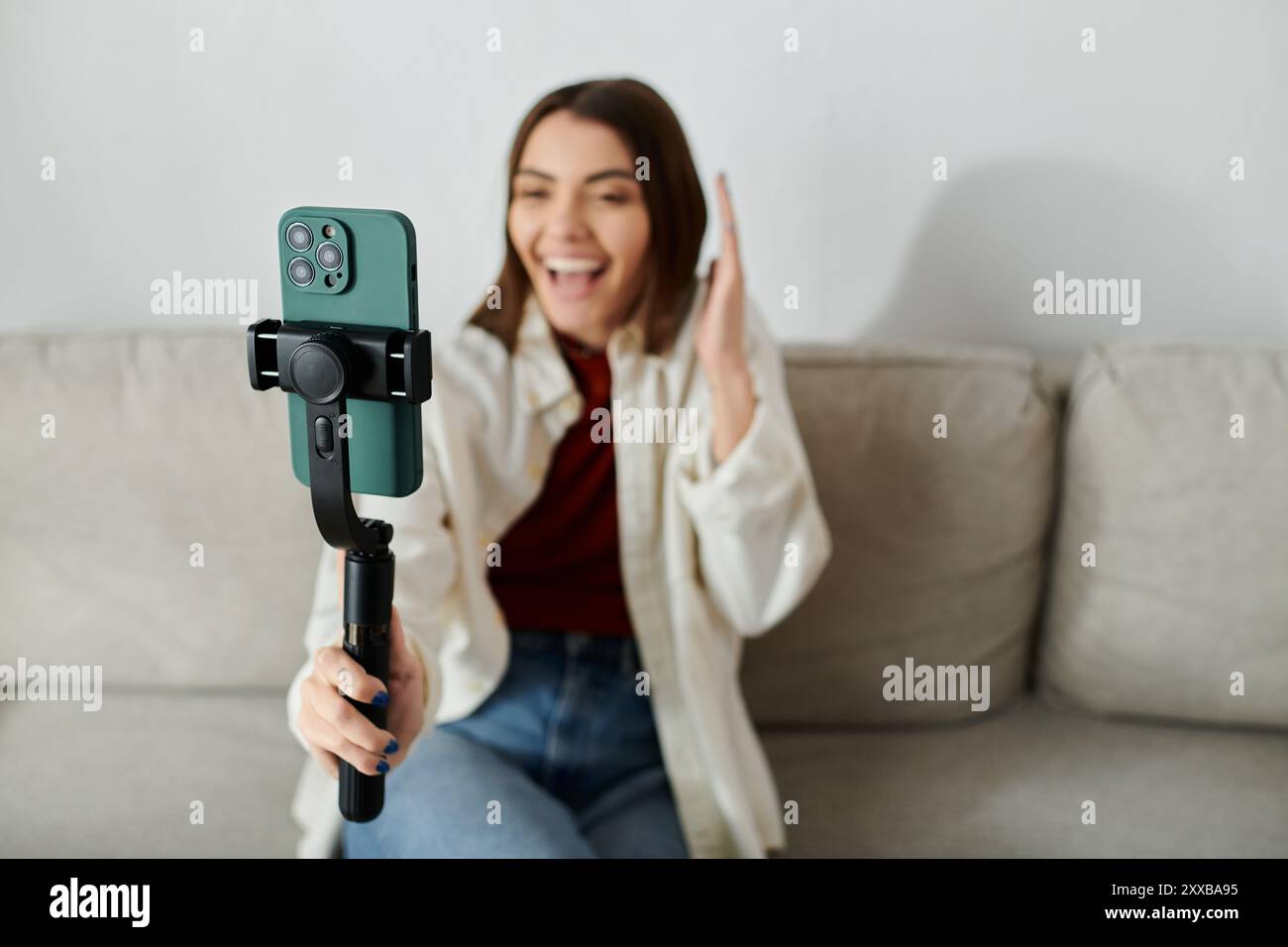 A Smiling Young Woman Films A Vlog While Sitting On A Couch Using A 4448
