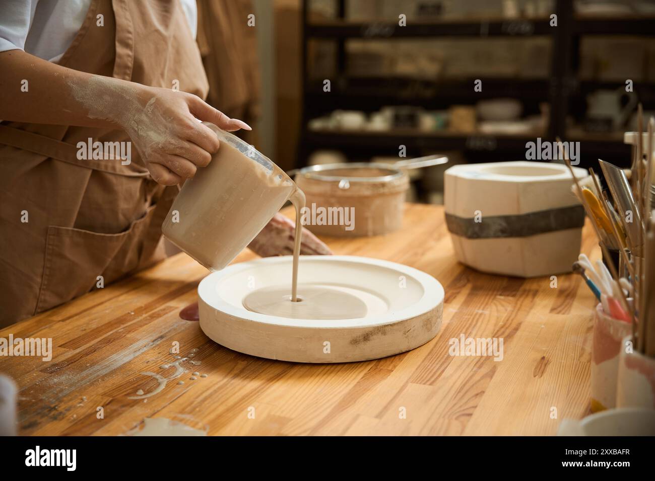 Female hands pour pottery mixture into a mold Stock Photo - Alamy