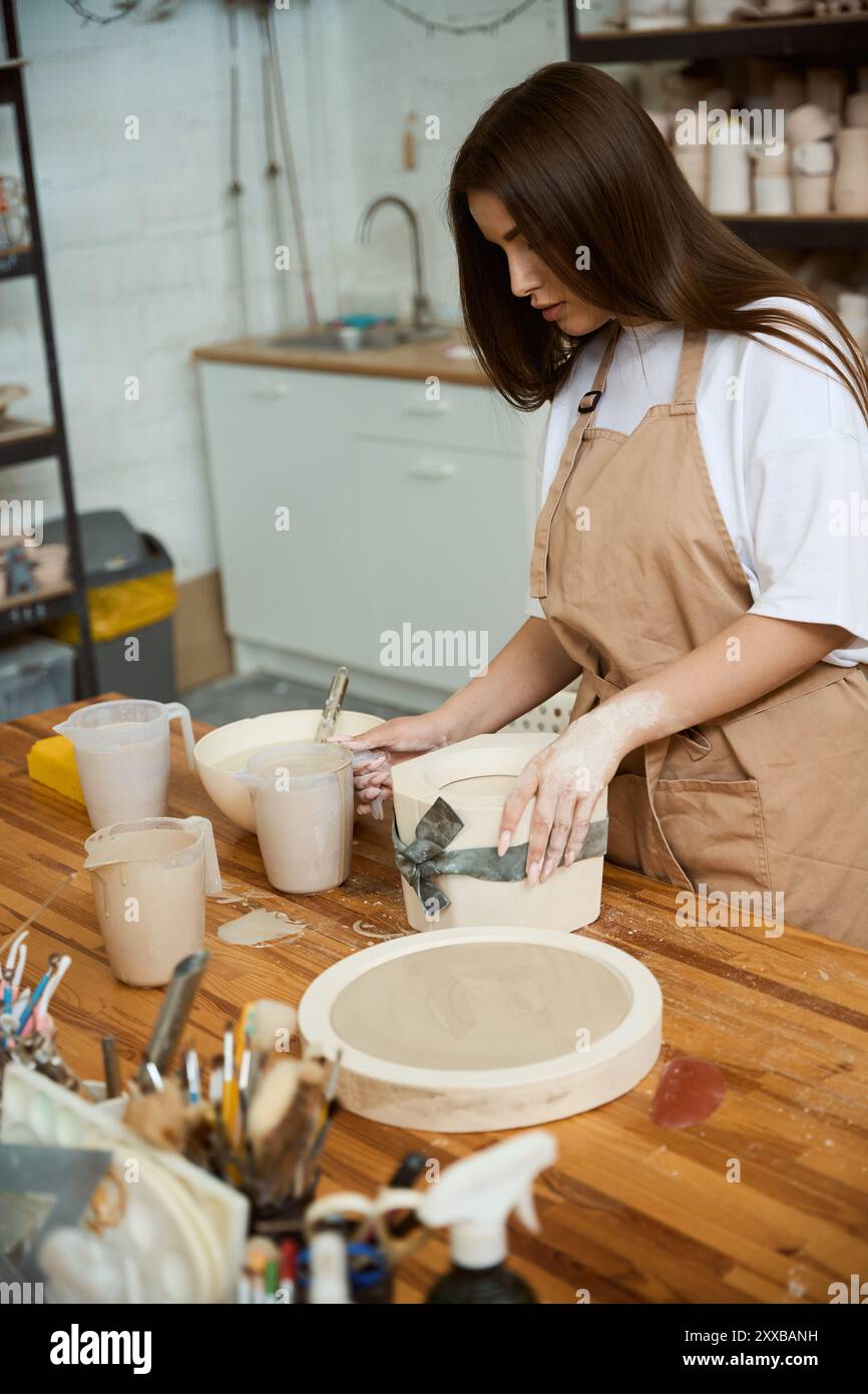 Female pouring pottery mixture into a mold in creative studio Stock ...