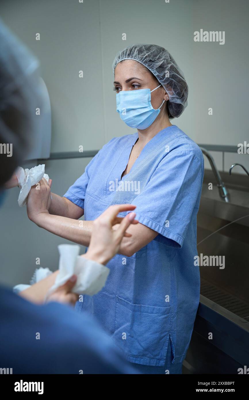 Female surgeons washing thoroughly hands before performing surgery in ...