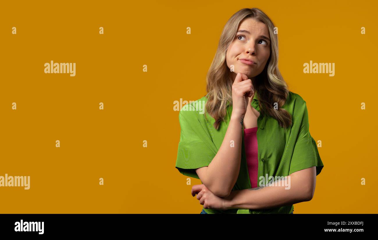 Thinking around 30s aged woman on yellow studio background. Smart lady ...