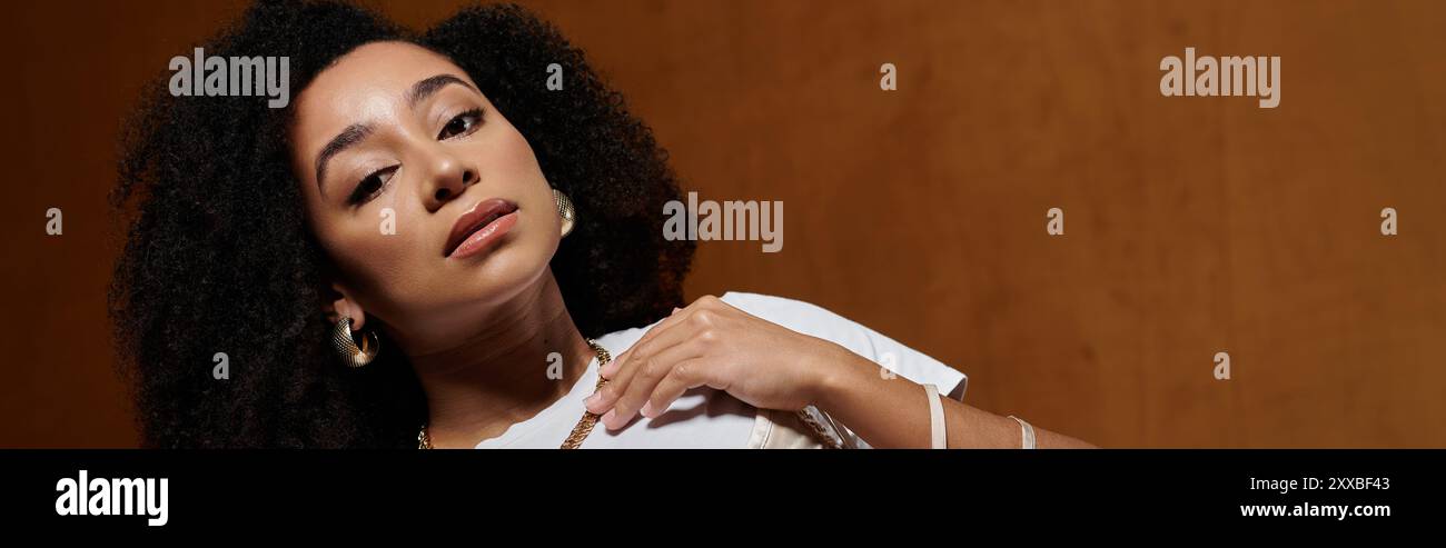 A stylish African American woman poses in a studio setting, her hand ...