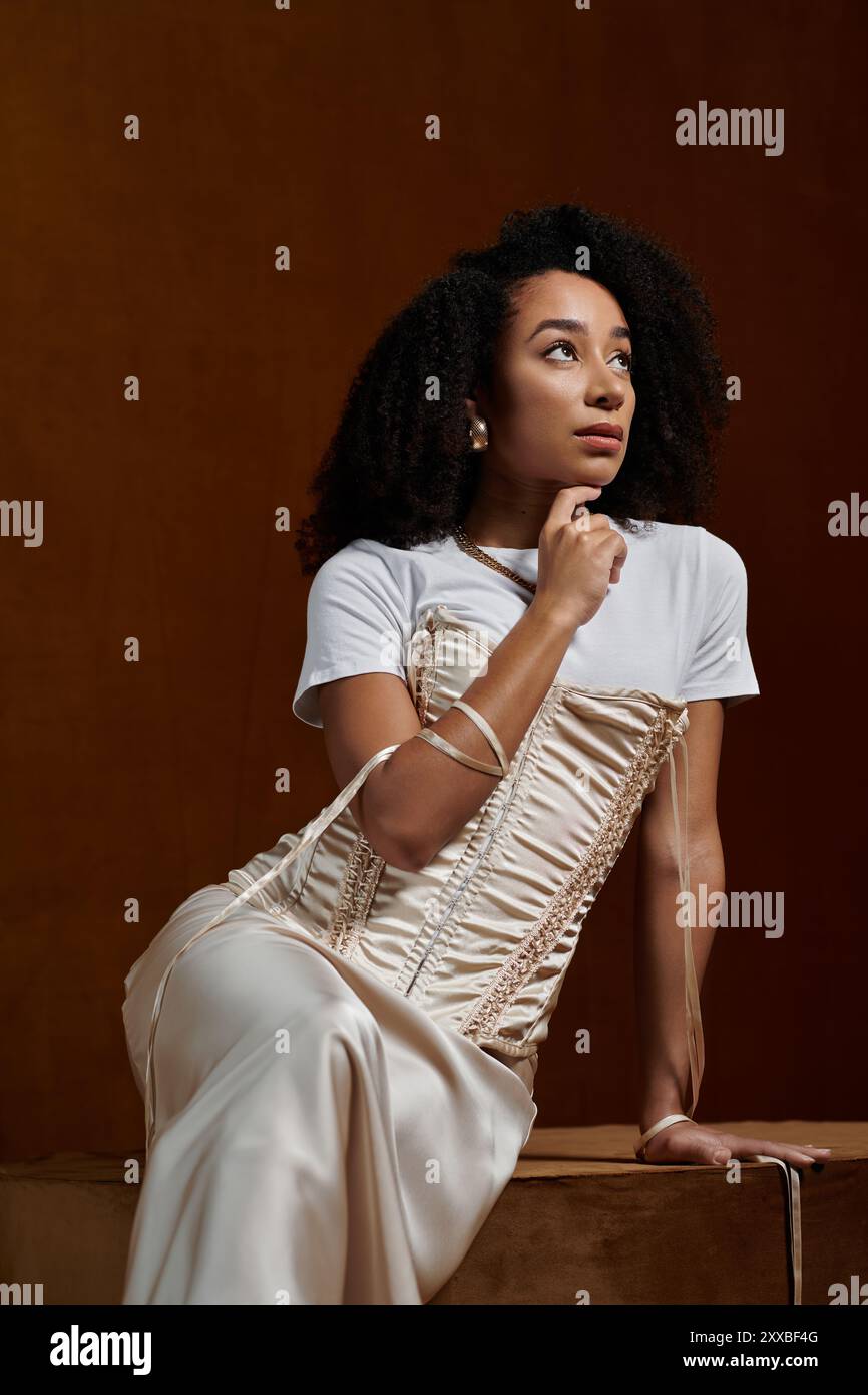 A stylish African American woman in a white top and a long, cream ...