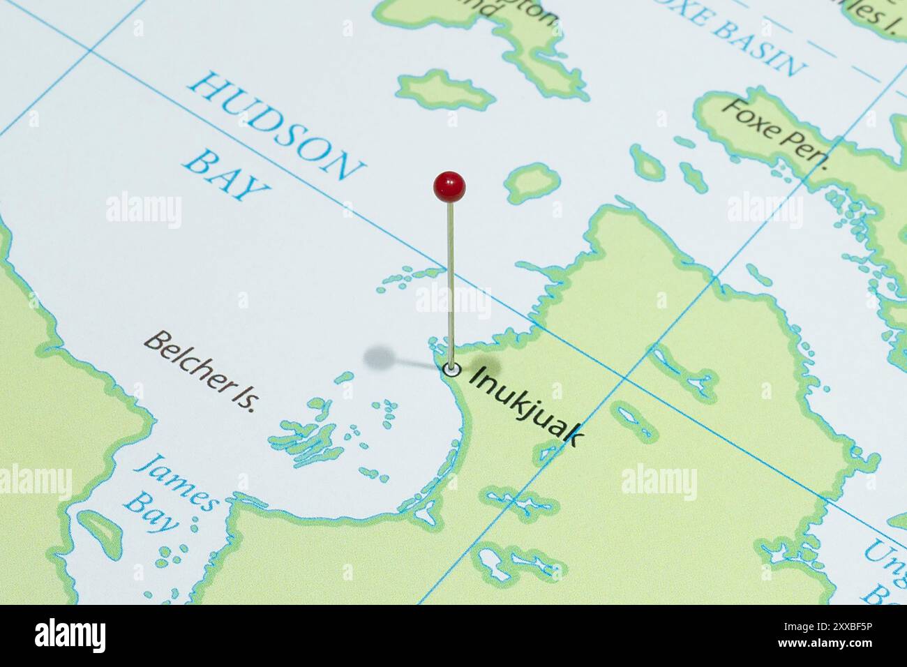 Close up to a Inukjuak city with a red pin needle into Canada country ...