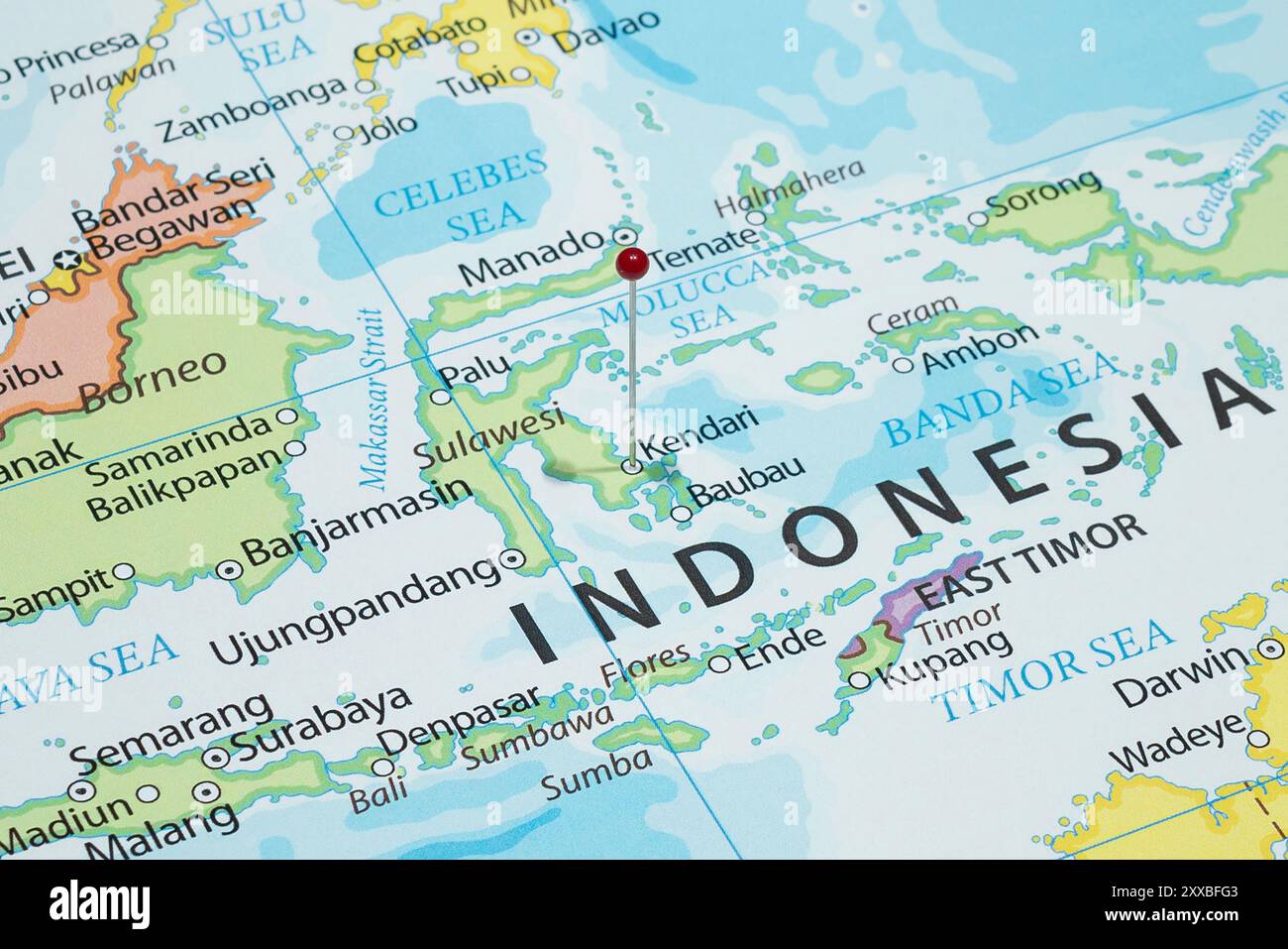 Close up to a Kendari city with a red pin needle into Indonesia country ...