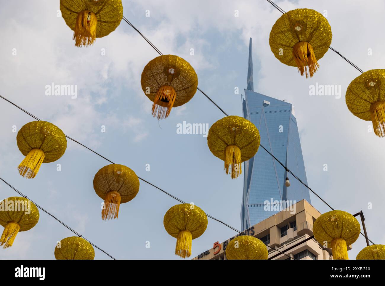 A picture of yellow paper lanterns hanging in the air while the Merdeka ...