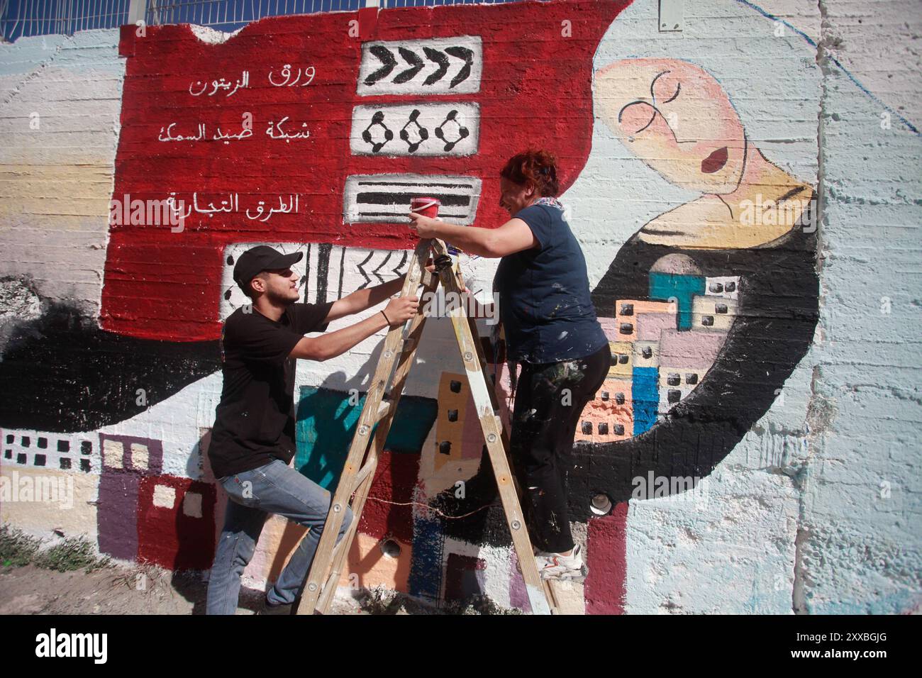 Palestinian artist Mays Abu Saa paints a mural of the Old City of ...