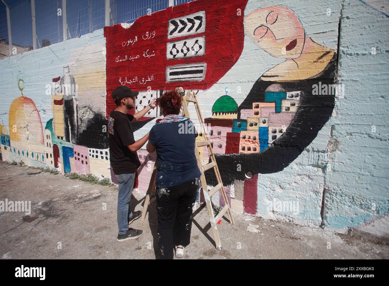 Palestinian artist Mays Abu Saa paints a mural of the Old City of ...