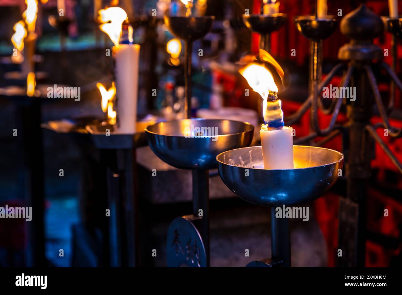 Many candles are burning in a temple, creating a spiritual atmosphere ...