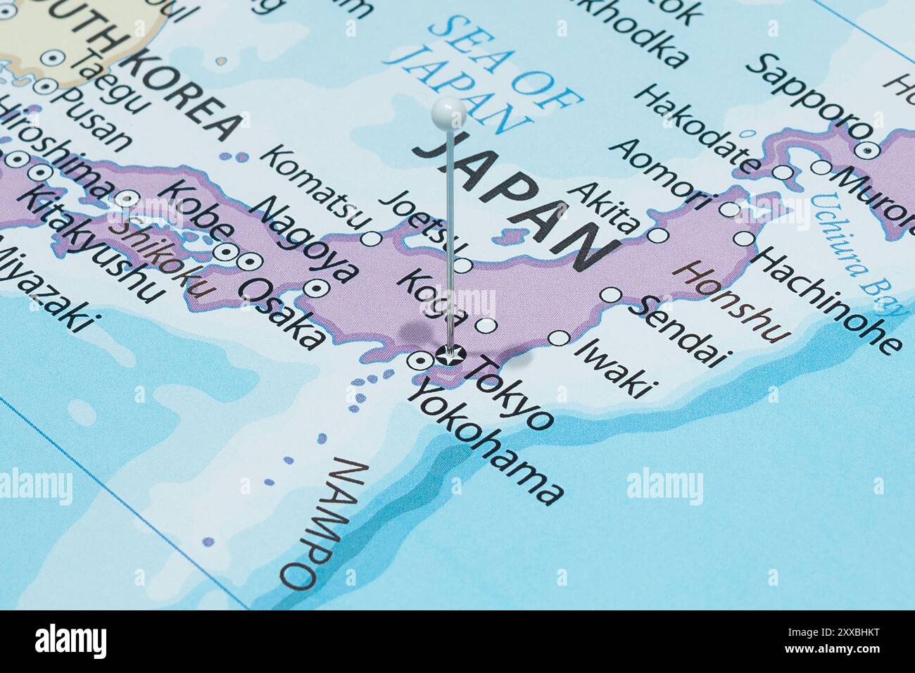 Macro photo of Tokyo city with a white pin needle into Japan country ...