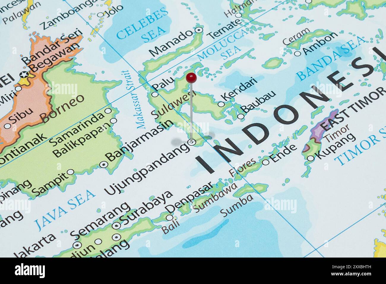 Close up to a Makassar city with a red pin needle into Indonesia ...