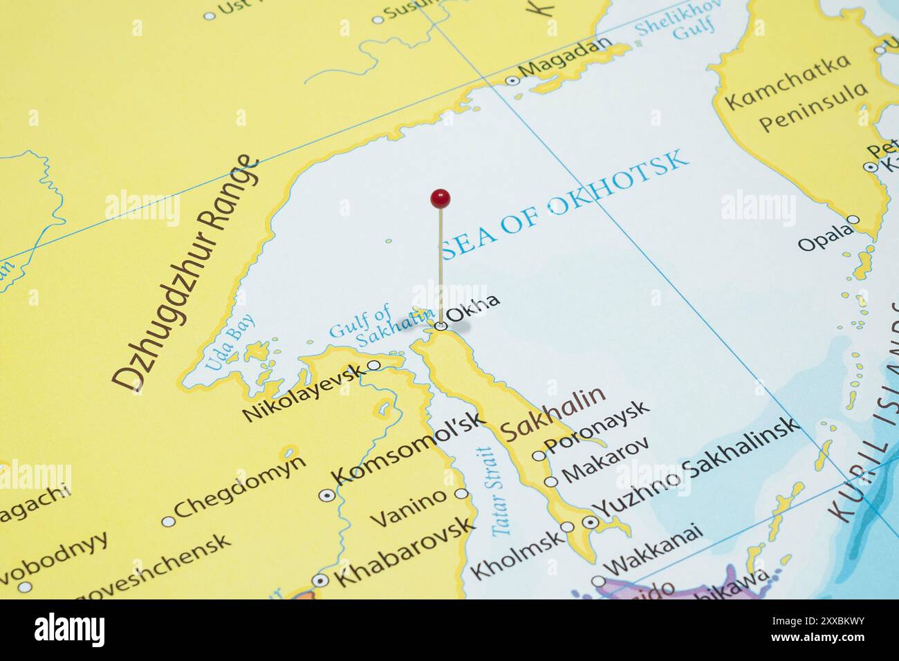 Close up to a Okha city with a red pin needle into Russia country ...