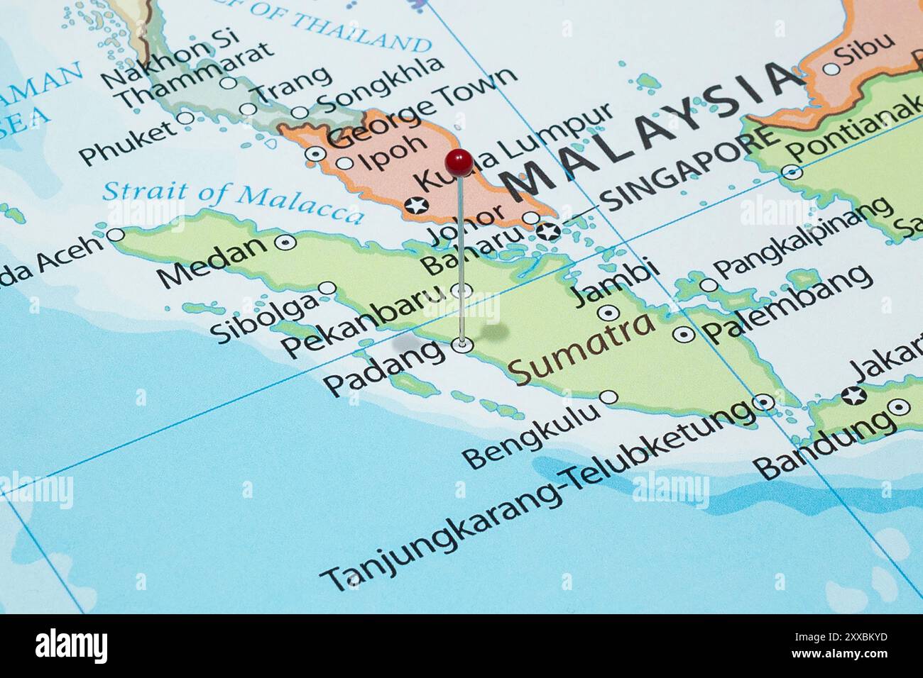 Close up to a Padang city with a red pin needle into Indonesia country ...