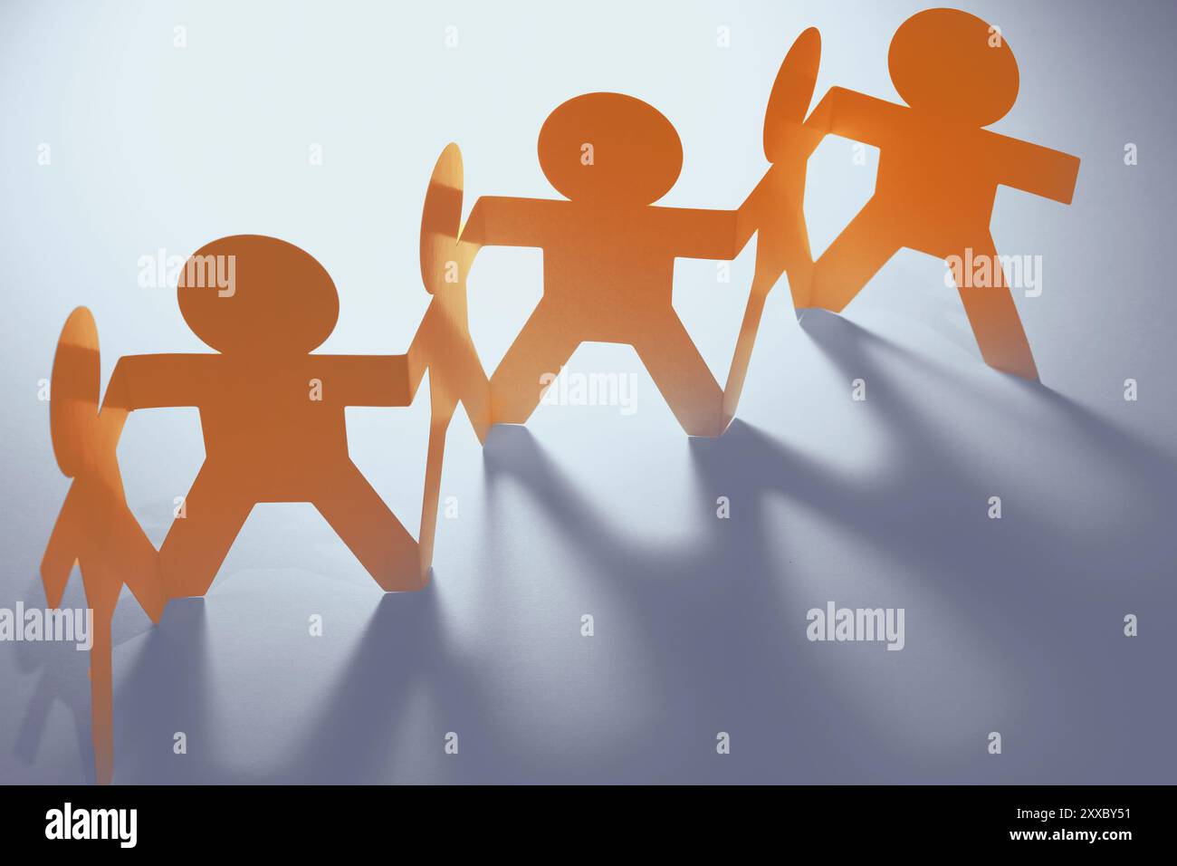 Team of paper chain people united together holding hands Stock Photo ...