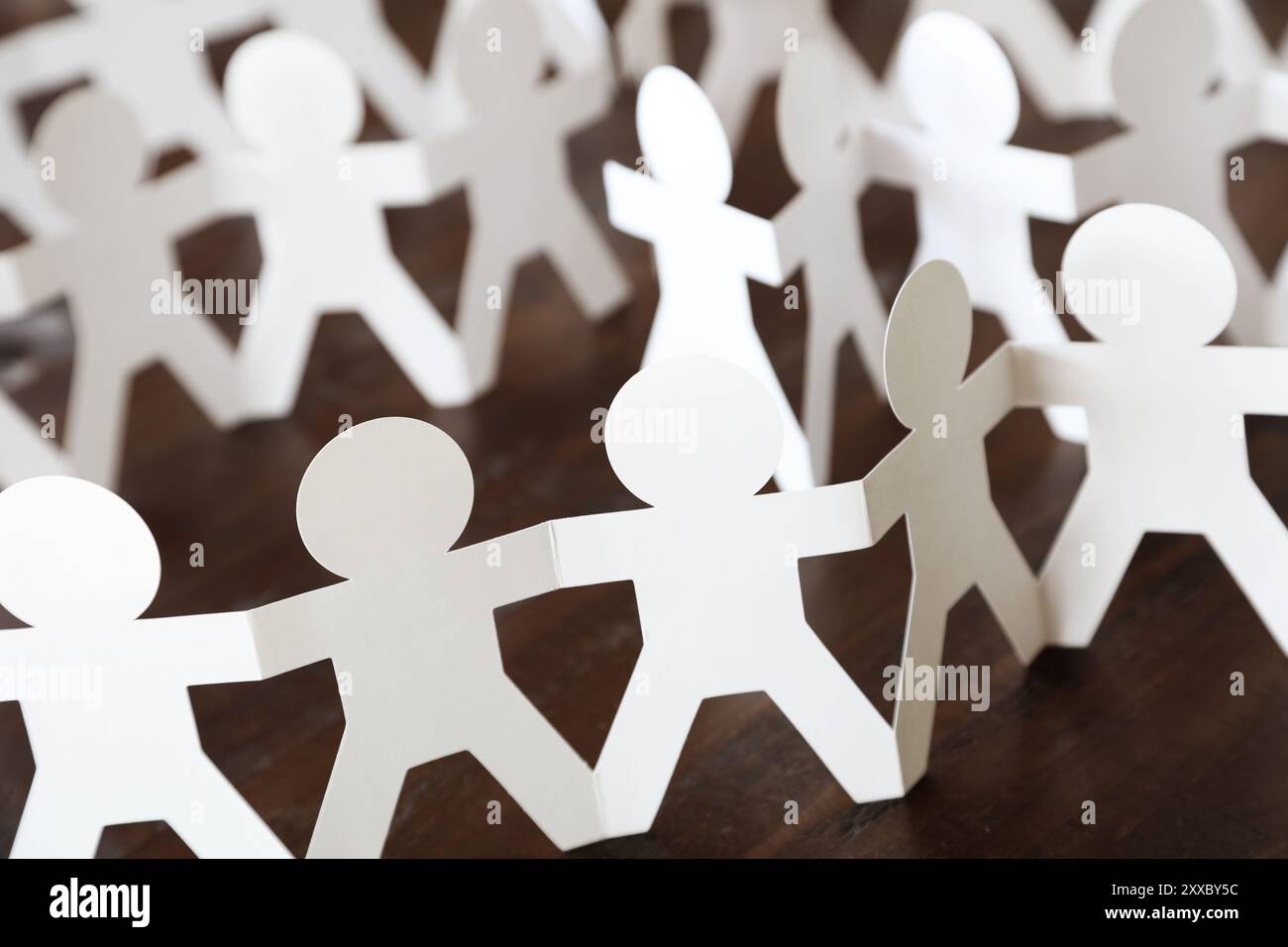 Team of paper chain people united together holding hands Stock Photo ...