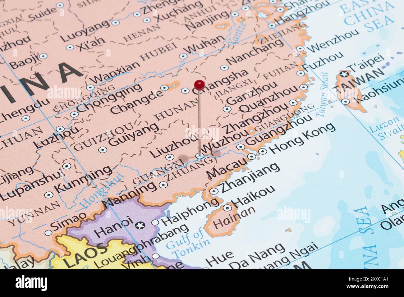 Close up to a Wuzhou city with a red pin needle into China country ...