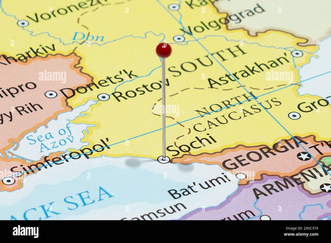 Close up to a Sochi city with a red pin needle into Russia country ...