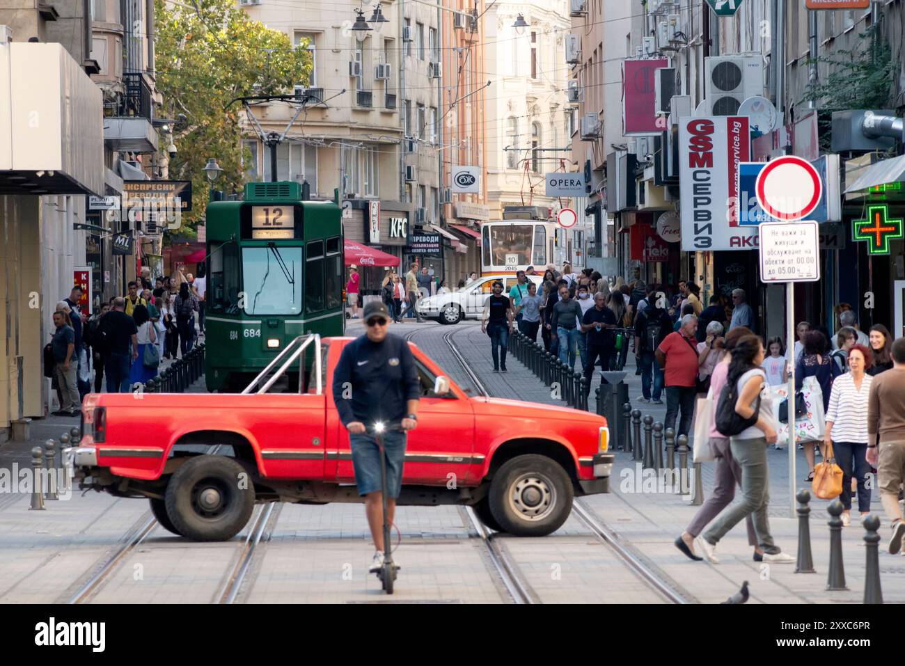 Busy urban street scene during rush hour with car traffic commuters ...