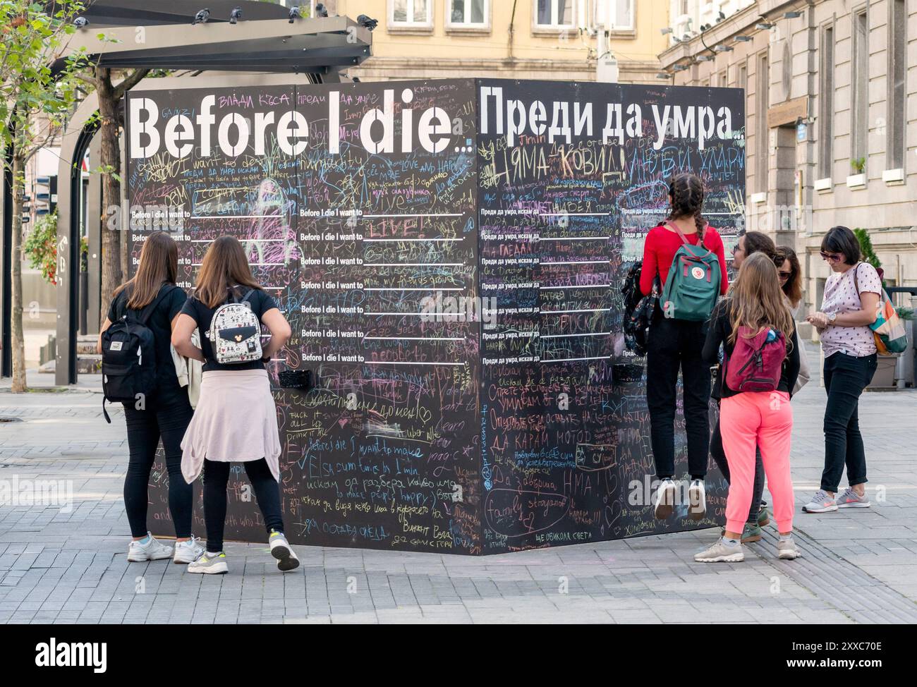 Group of teenage girls hanging out at a blackboard or chalkboard wall ...