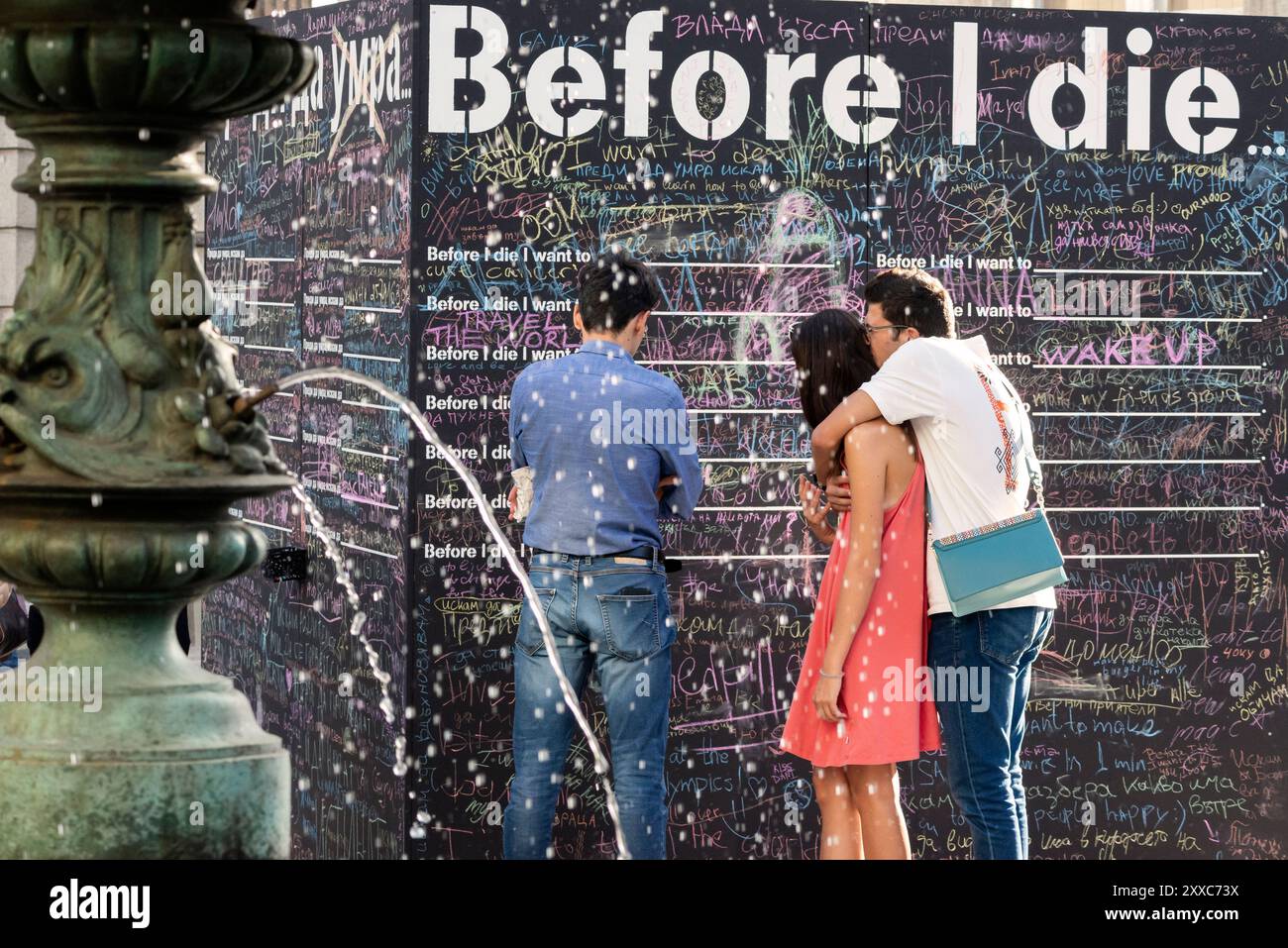 Members of the public writing and reading messages on a blackboard or ...