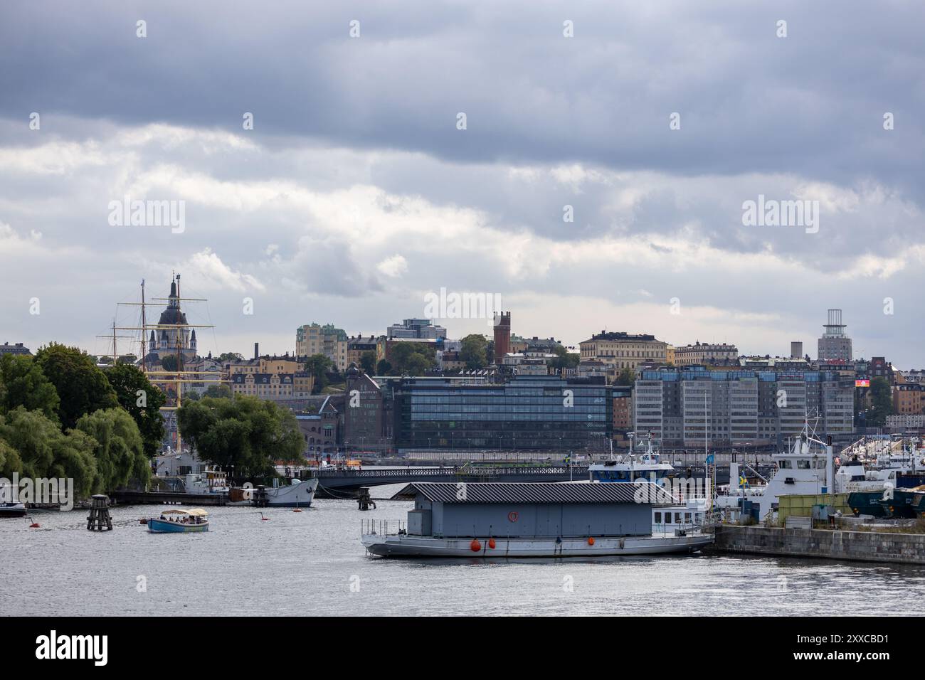 A scenic view of a waterfront city with boats, modern buildings, and ...