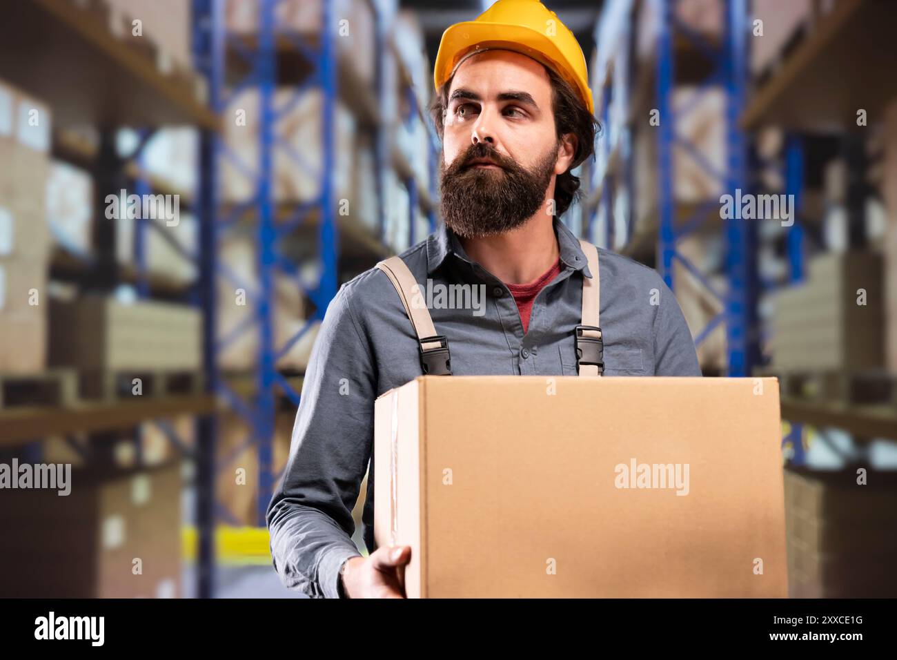 Facility manager carrying boxes with merchandise around depot, working ...