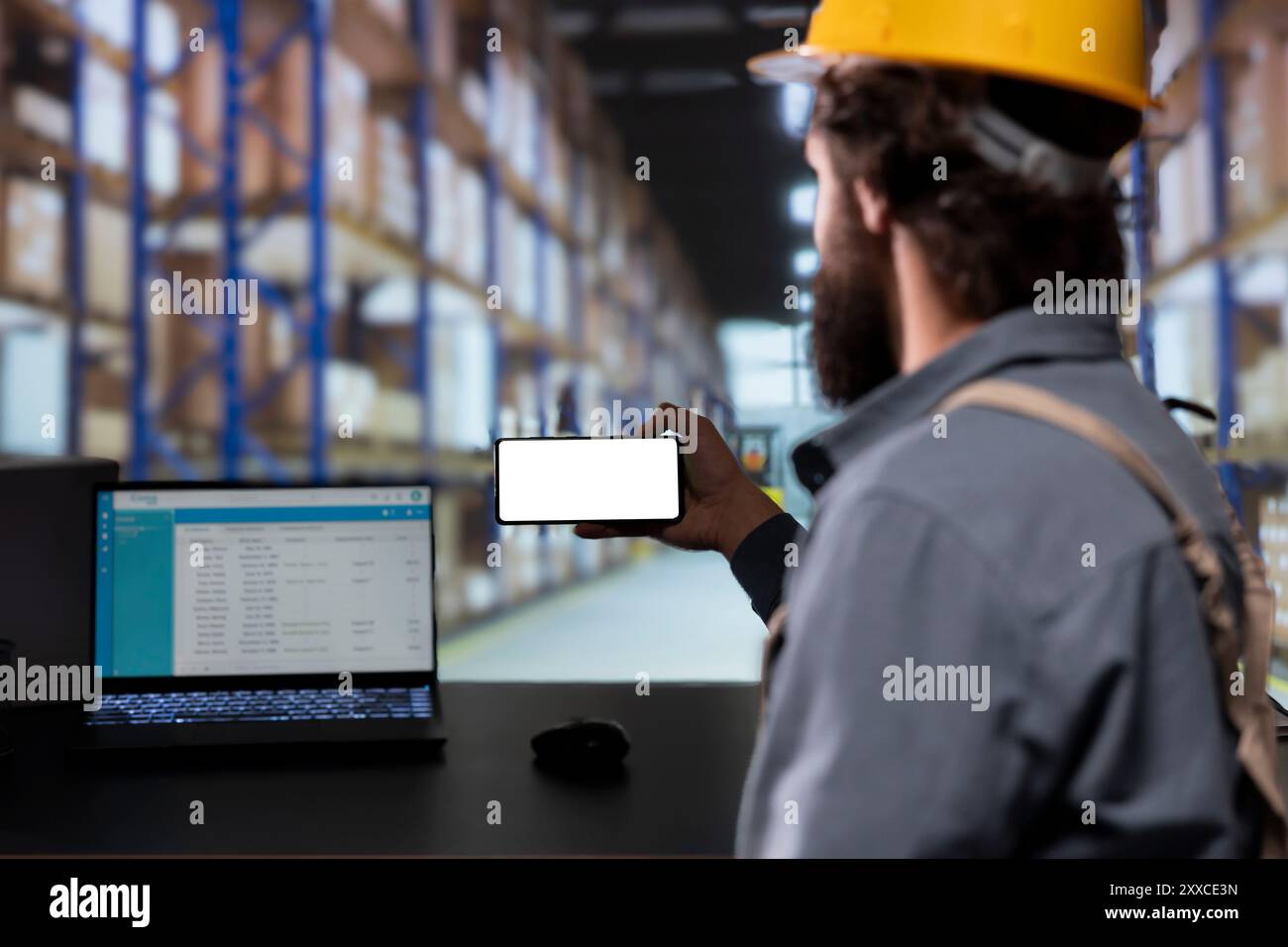 Warehouse worker presenting at phone screen with white layout, handling ...