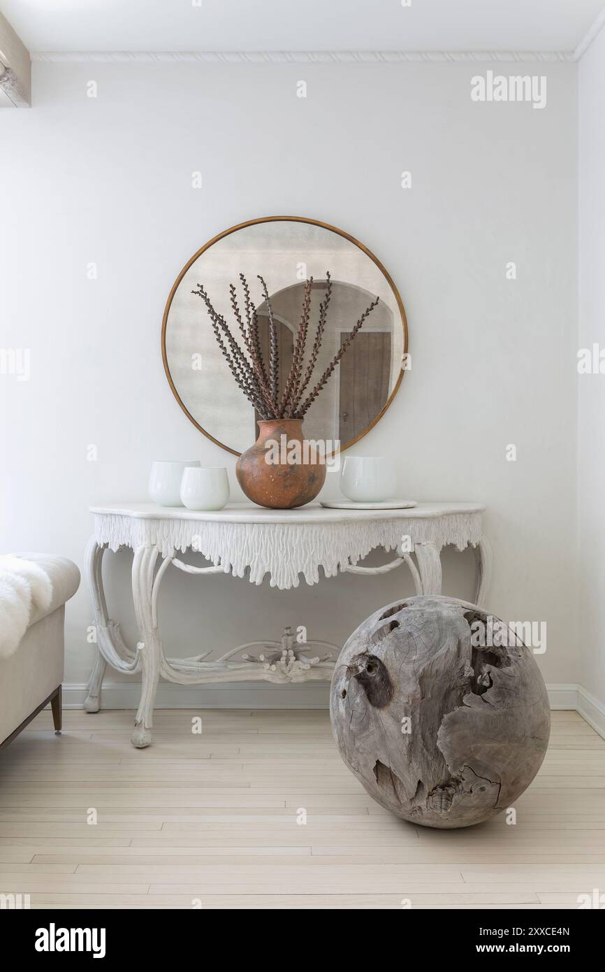 Corner of white living room with artistic console table with vase and ...