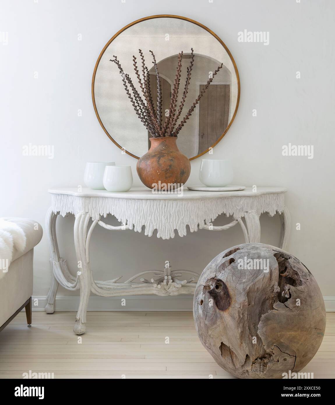 Corner of white living room with artistic console table with vase and ...