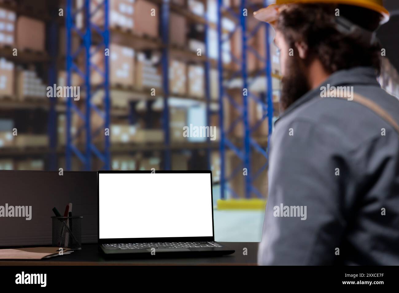 Distribution advisor looking at white screen on laptop working in depot ...