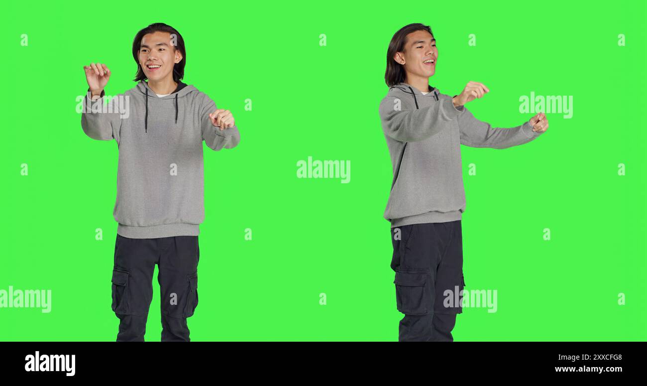 Asian guy acting as choir conductor for musical show, moving hands like ...