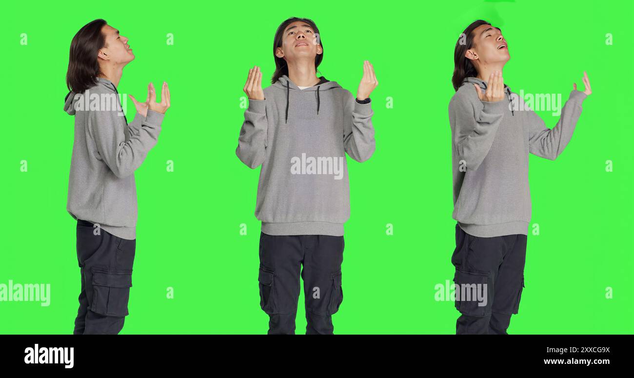 Model with belief praying to God against greenscreen studio backdrop ...