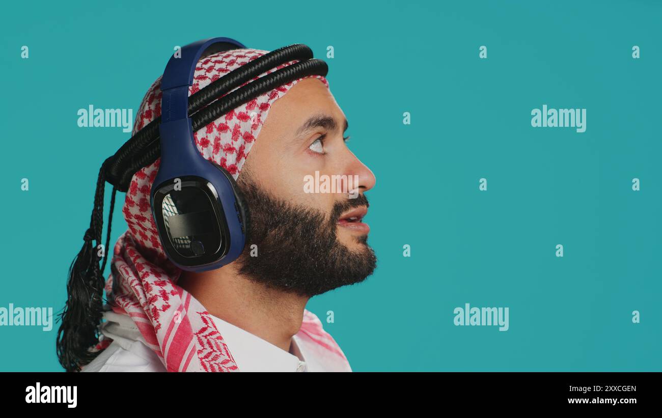 Cheerful guy dancing around in studio, listening to modern tunes on ...