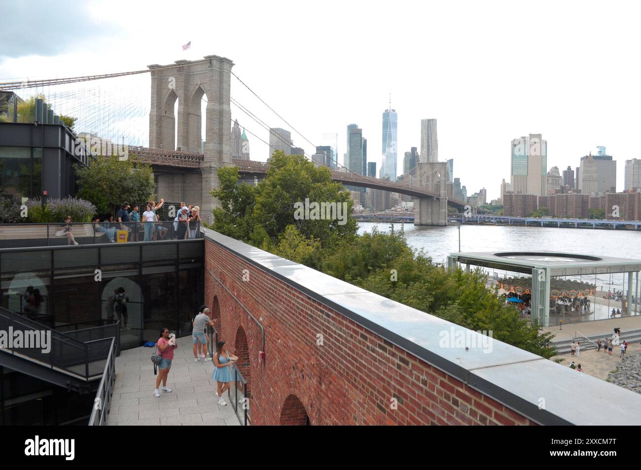 People are seen on a rooftop in Dumbo in front of a view of the ...