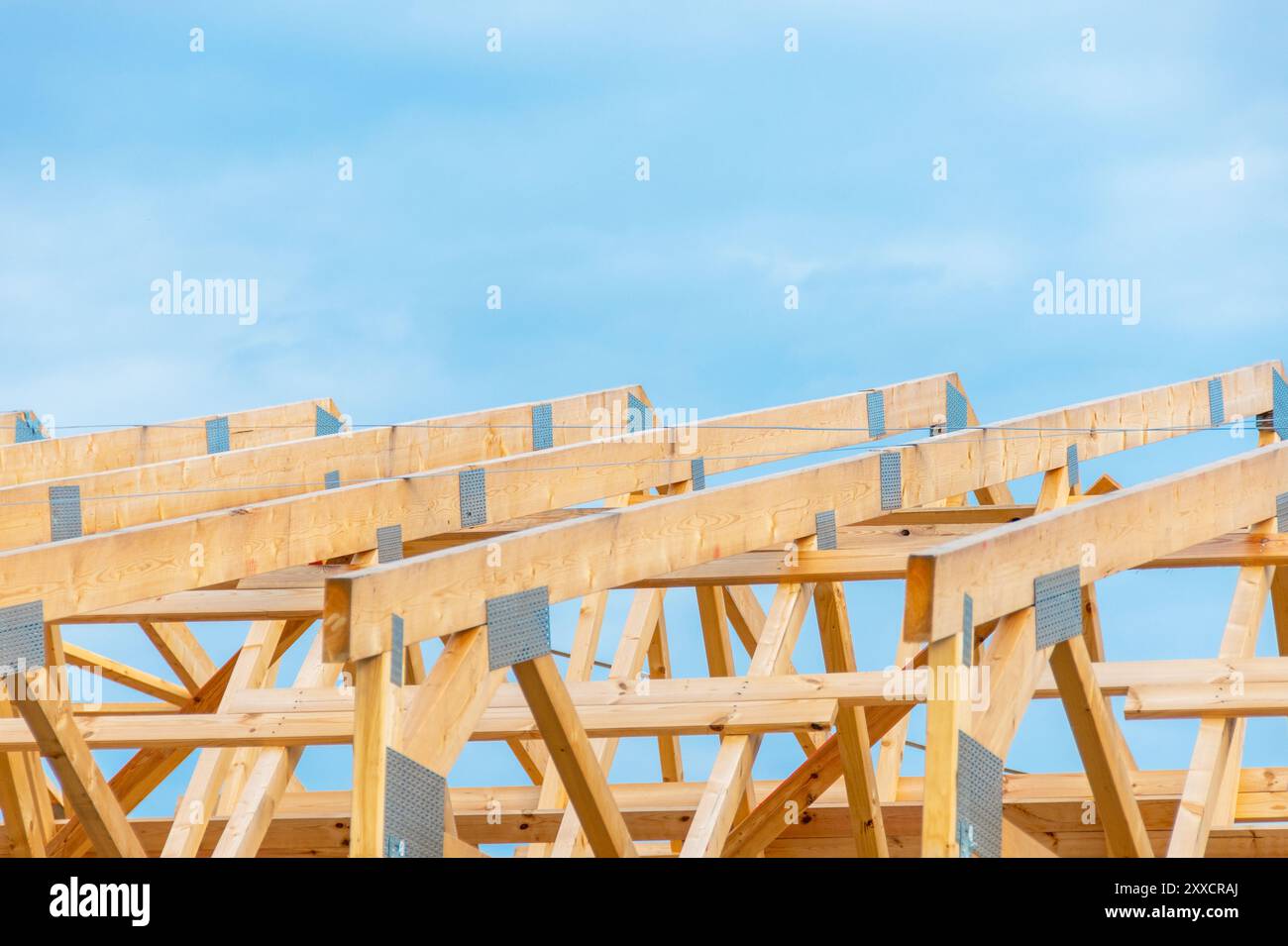 Wooden trusses frame a roof in a construction site, showcasing strong ...