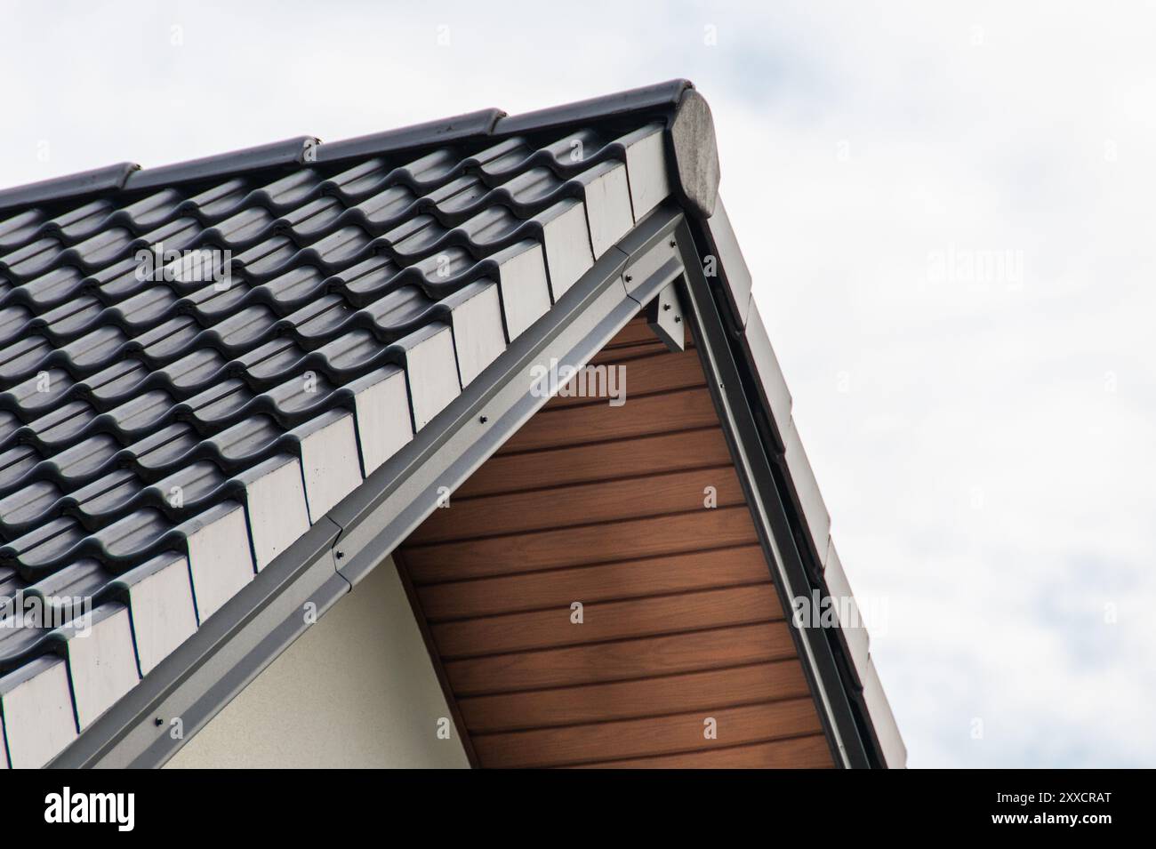 Stylish roof detailing with black tiles, wooden eaves, and a clear sky ...
