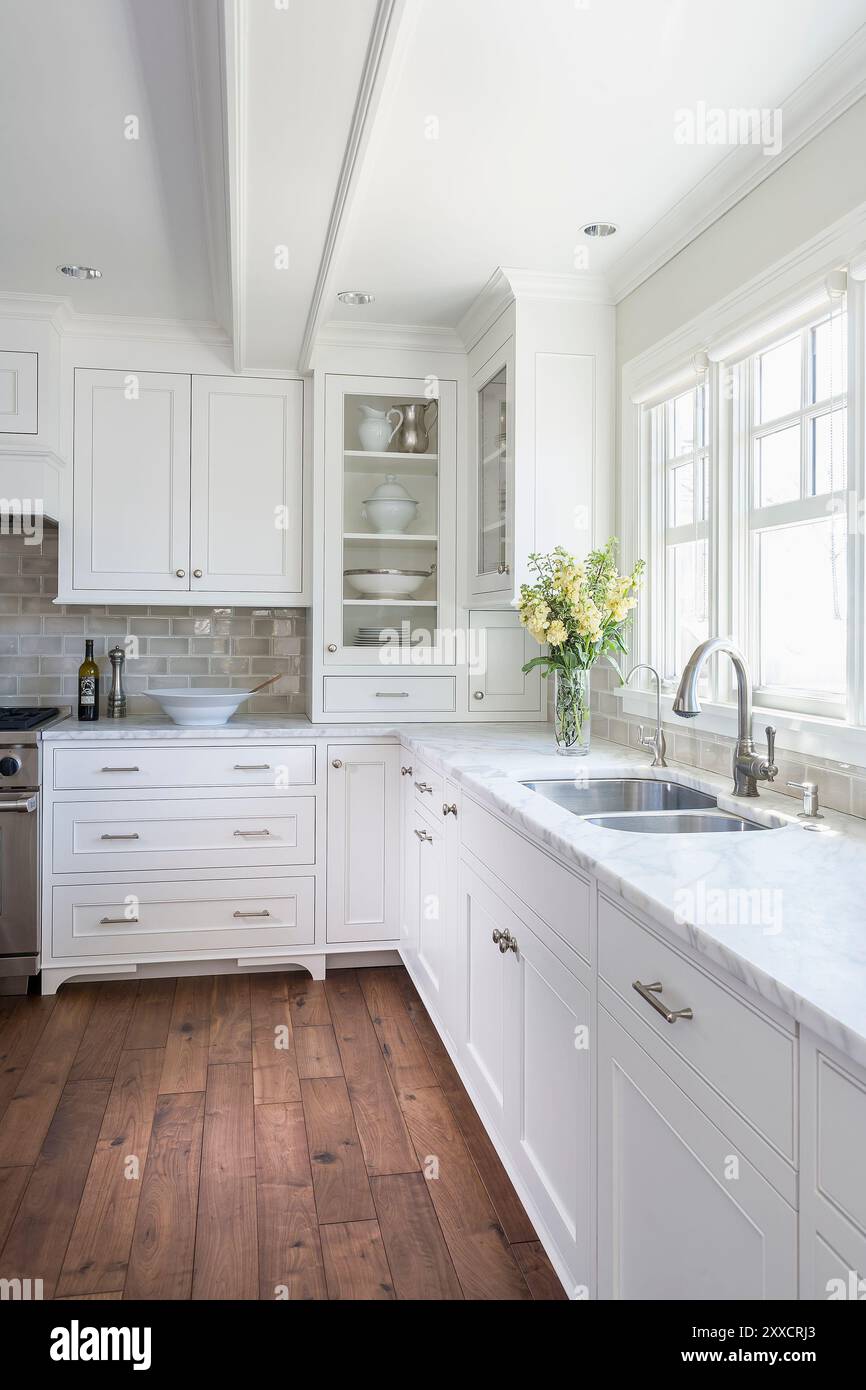 Corner of white kitchen showing sink and corner display cabinets Stock ...