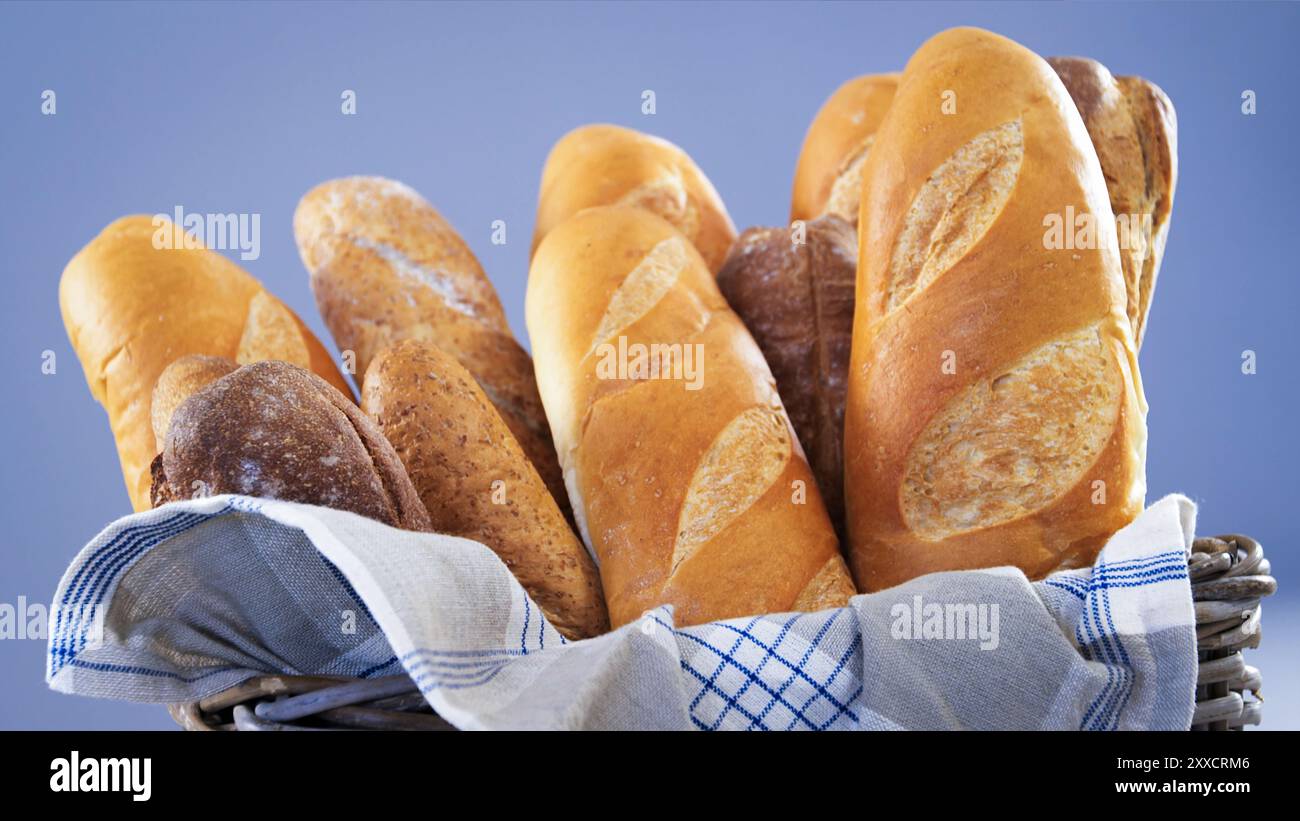 Different types of bread in a rustic basket isolated on a blue ...