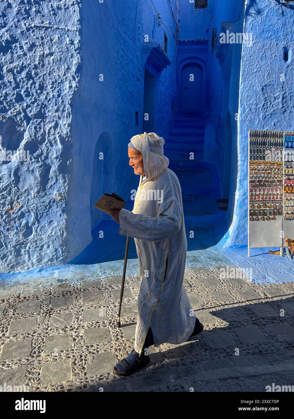 An old man walking the indigo Chefchaouen streets, Morocco Stock Photo ...