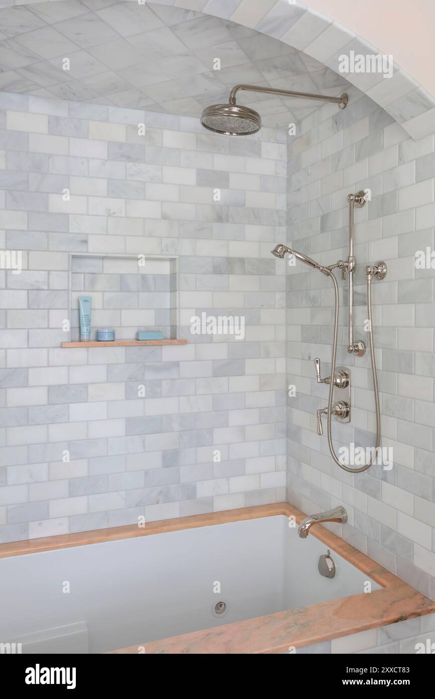 Marble tiled shower and bathtub in arched alcove Stock Photo - Alamy